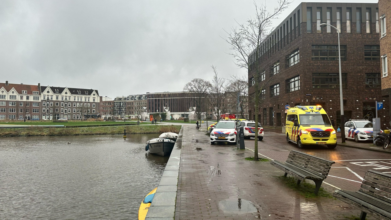 Omstanders houden hoofd van in gracht gevallen man boven water in ...