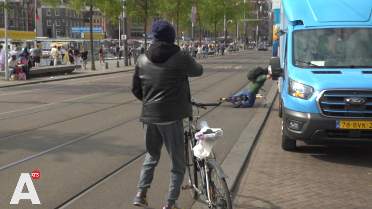 Fietspad Damrak vol vrachtwagentjes, fietser valt op trambaan ...